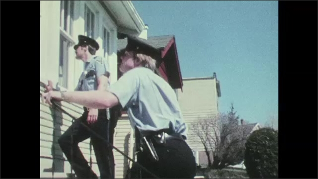1970s: UNITED STATES: police officers visit house. Police officer looks ...