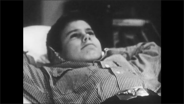 1950s: UNITED STATES: boy sulks on bed. Boy thinks to self. Boy stares ...