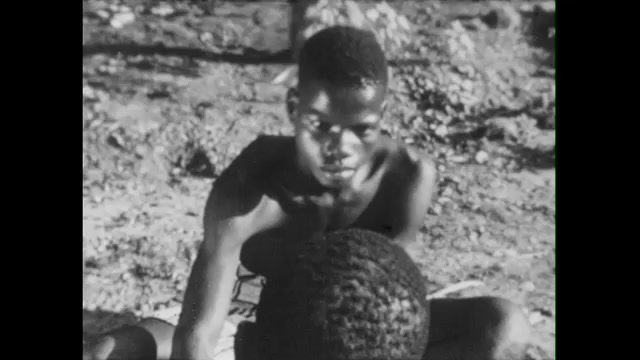 1940s: Boy traces shape of cross in dirt. Boy and man carry – Archival ...