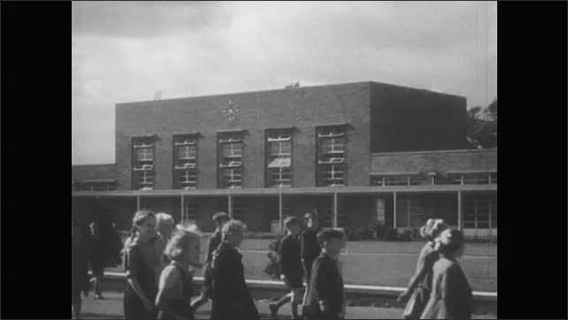 1940s: Children leave playground, walk towards school building ...