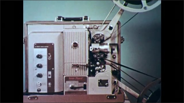 1950s: UNITED STATES: film threaded on projector. Motion picture ...