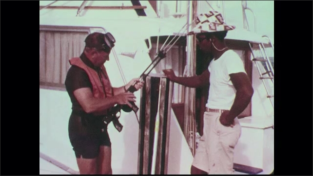 1960s: Scuba diver demonstrates double-barreled underwater spear gun ...