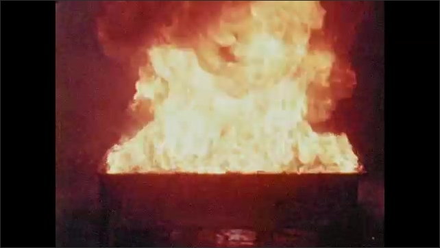 1950s: Flaming basin of liquid, sprinkler water sprays around fire ...