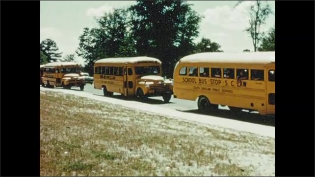 1950s: Students load school buses. Buses drive away. – Archival Footage