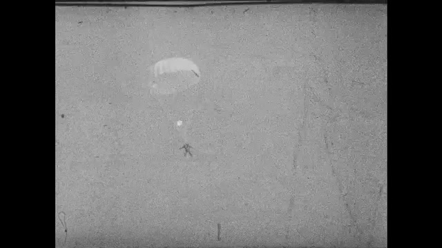 Germany 1940s: Paratrooper parachutes to the ground. Airplane takes off ...
