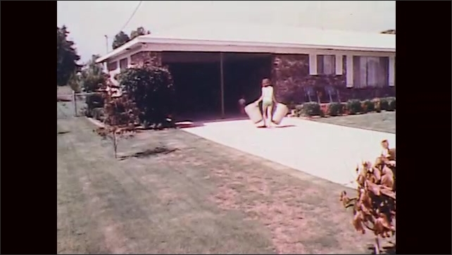 1970s: UNITED STATES: man empties bins into rubbish truck. Lady brings ...