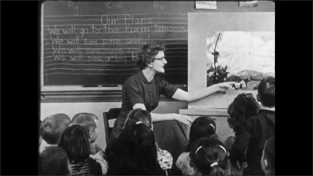 1950s: UNITED STATES: teacher in classroom. Children look at teacher in ...