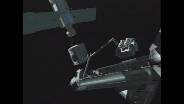 1990s: Space shuttle with open bay doors docks with International Space ...