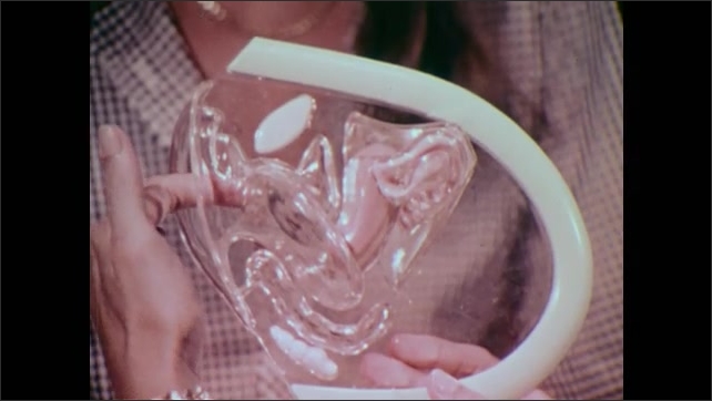 1980s: UNITED STATES: lady puts down diaphragm. Clear plastic model of ...