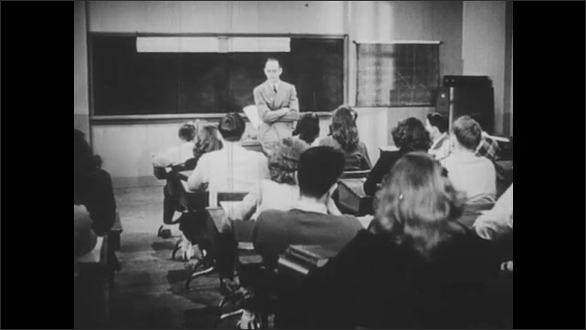 1940s: Teacher looks concerned as he talks to class. – Archival Footage