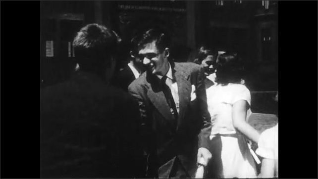 1950s: Happy and relaxed parents of teen boy sit in graduation audience ...