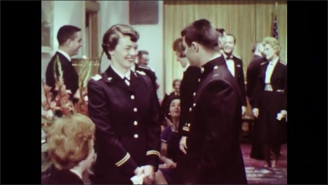 1970s: UNITED STATES: military officers meet at party. Uniformed medics ...