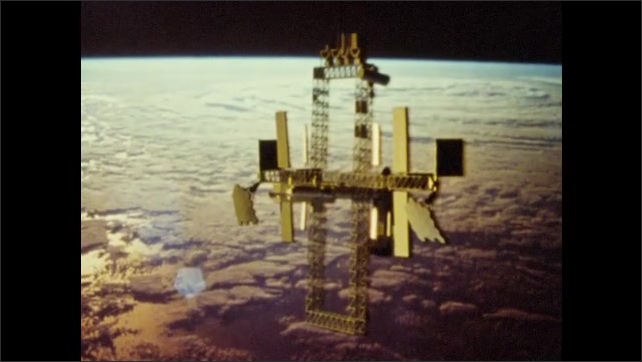 1980s: Planet Earth rotates. Model of space station. Man stands inside ...