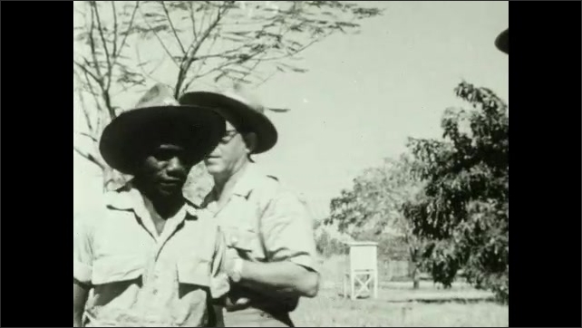 1930s: Men talk outside building labeled “POLICE STATION.” Men mount ...