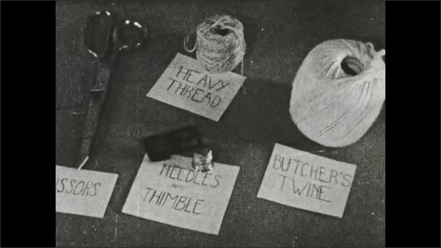 1930s: Title card. Scissors, needle, twine and thread laid out with ...