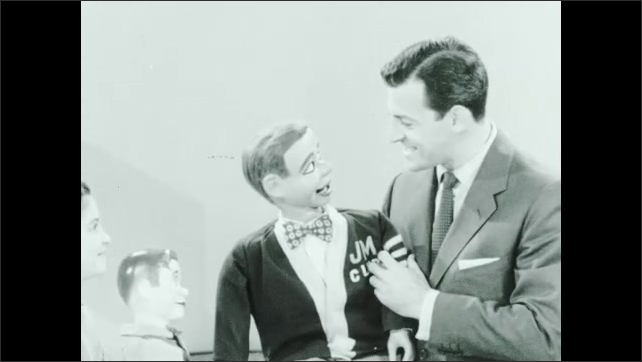1960s: Man and ventriloquist dummy talk. Girl holds ventriloquist dummy ...