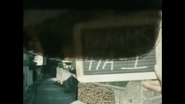 1950s: Houses in village, castle on hillside. Clapboard. Water flowing ...