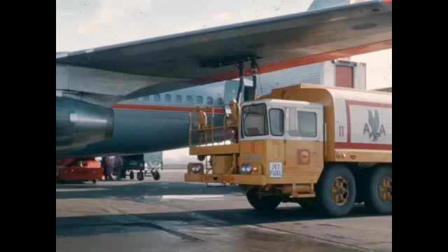 1960s: American Airlines refuels airplane with jet fuel. Gas puddle in ...