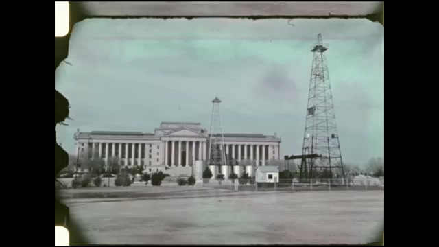 1950s: large classical style building with columns, cars driving down ...