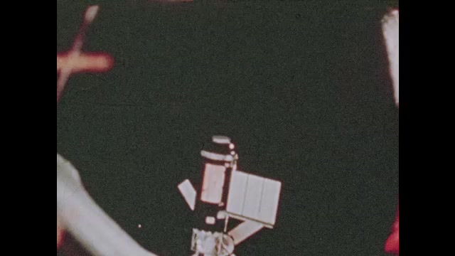 1970s: Satellite in space. View of earth from space. Astronaut at work ...