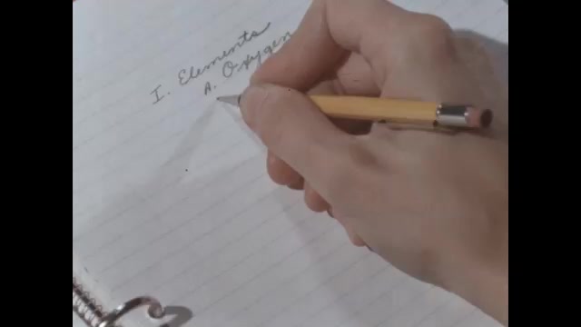 1940s: Boy writes in cursive in binder. Boy writes lists of elements ...