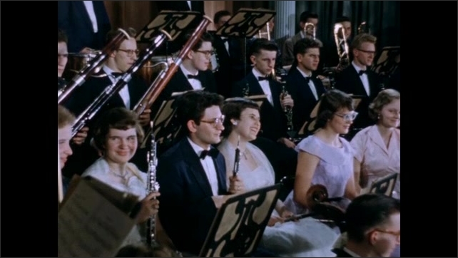 1950s: Man holding clapperboard, clapping. Orchestra holding ...