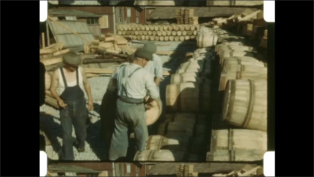 1950s: Man and boy sprinkle salt over fish in crate. Man writes in ...