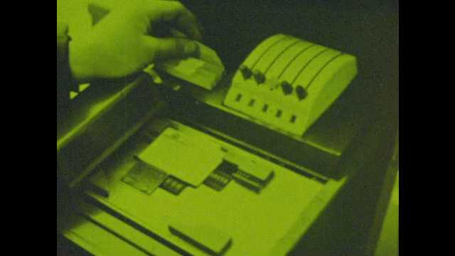 1970s: Person processes credit card transaction. Woman signs receipt ...