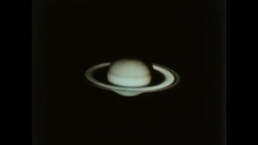 1980s: Planet Saturn photograph. Animation of rocks, particles in ring ...