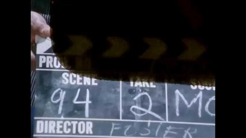 1960s: film slate, boy sits while girl behind him starts reading aloud ...