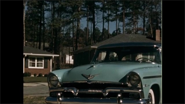 1950s: Teen boy cleans headlights, grill and back windshield of blue ...