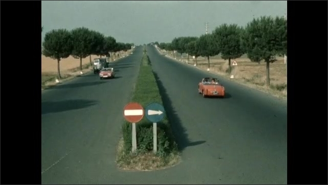 1950s: View of stone road. Pan of road. High angle, cars driving on ...