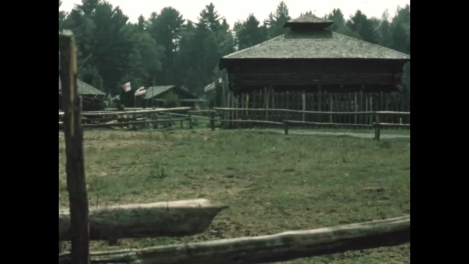 1950s: Four men with rifles and axes walk across an open space at a ...