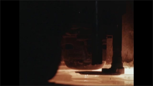 1960s: Industrial machine spinning. Molds dipping into molten glass ...