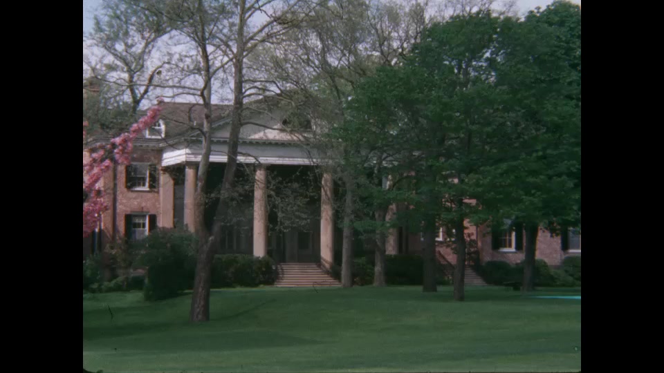 1960s: A formal building on well-kept grounds. – Archival Footage