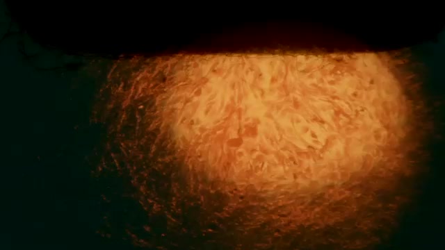 1950s: Yellow and orange fire like object. Microscopic particles ...
