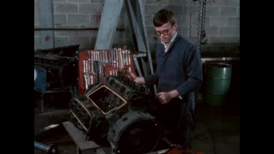 1960s: Mechanic attaching cylinder head to engine block. – Archival Footage