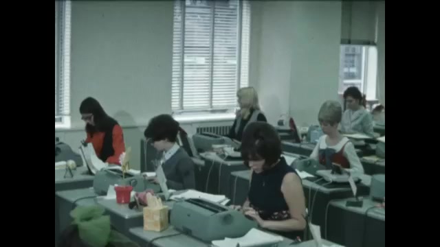 1960s: secretaries work in open plan office, ladies work on typewriters ...
