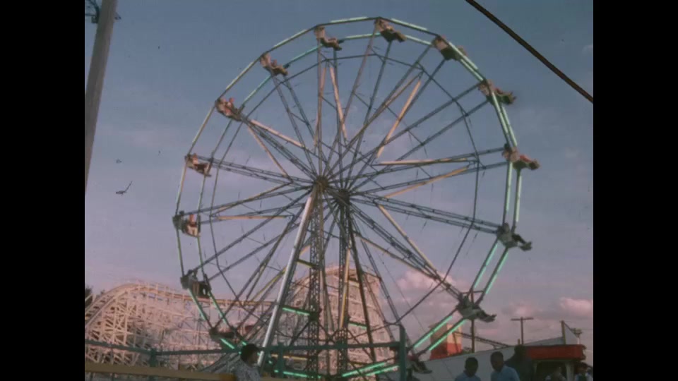 1950s: Men and children walk past Ferris wheel at carnival. – Archival ...