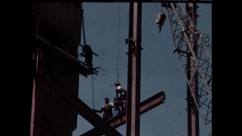 1950s: Crane lifts men on steel beam up the structure of skyscraper ...