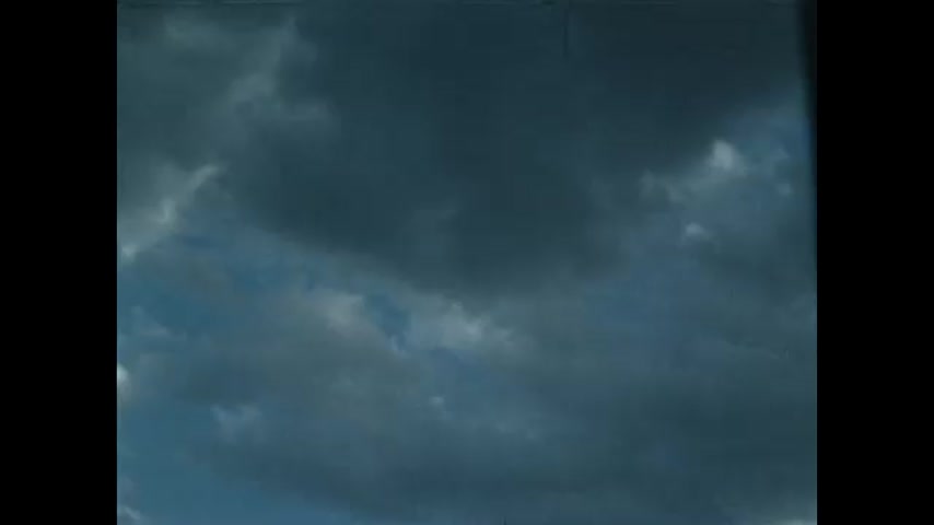 1960s: Lightning overlayed on a cloudy sky. Man holds a hand over a ...