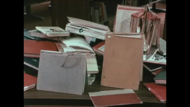 1970s: ruined books on desk, animated face appears on 1 book, mouth ...