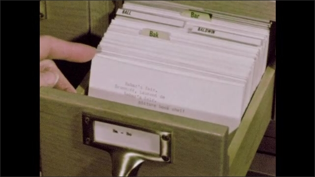 1960s: Library. Woman speaks. Librarian flips through card catalog ...