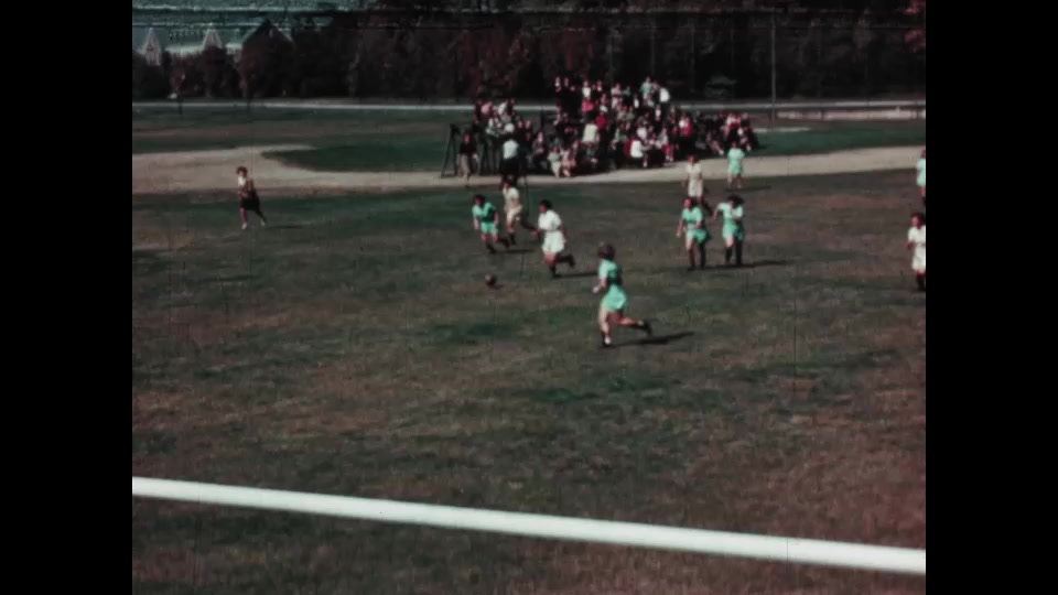 1950s: High angle panning shot, girls playing soccer. Girls cheering in ...