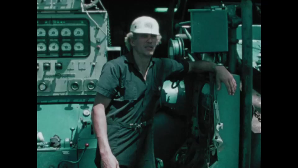 1970s: Worker leaning on the controls, waving his hand. Workers ...