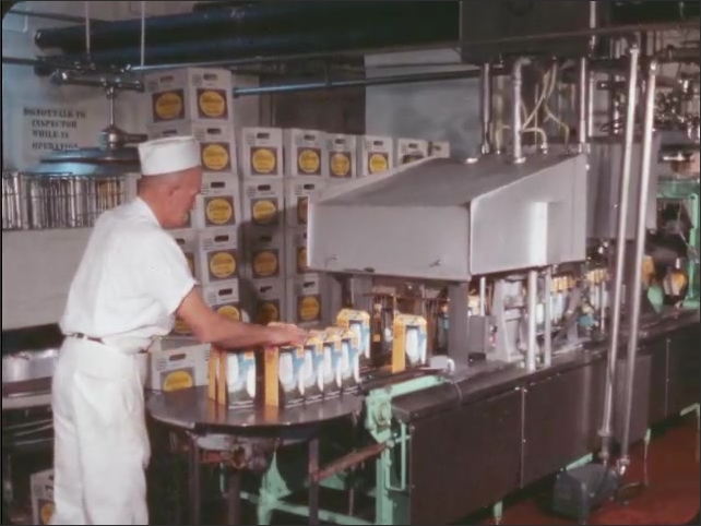 1960s: Man packages milk cartons into crates. Milk cartons move through ...