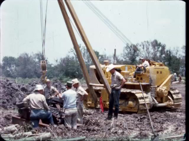 1940s: UNITED STATES: close up of digger bucket moving soil from ditch ...