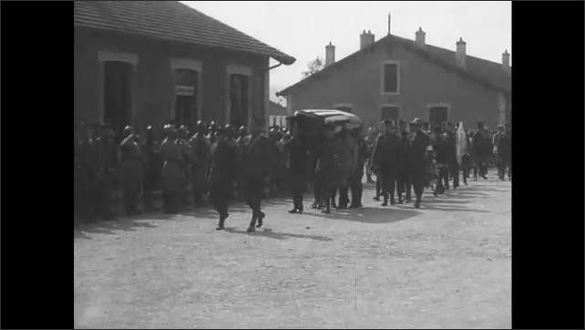 1910s: Soldiers stand at attention as troops carry flag-draped coffin ...
