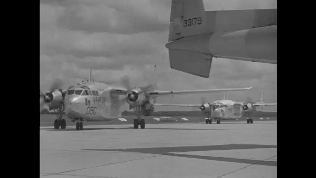 1940s: Air Force cargo planes on tarmac. Soldiers parachute from planes ...