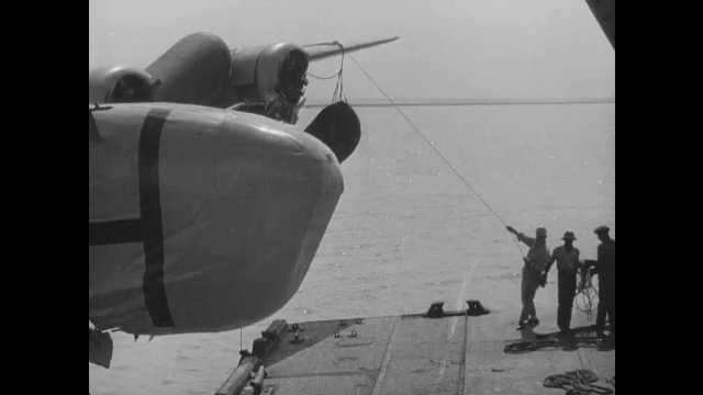 1940s Virginia: Men pull on rope, guide salvaged plane towards dock ...